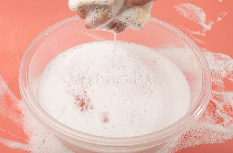 A Basin with Soapy Water, Hand Holds Soapy Sponge with Foam on Pink ...