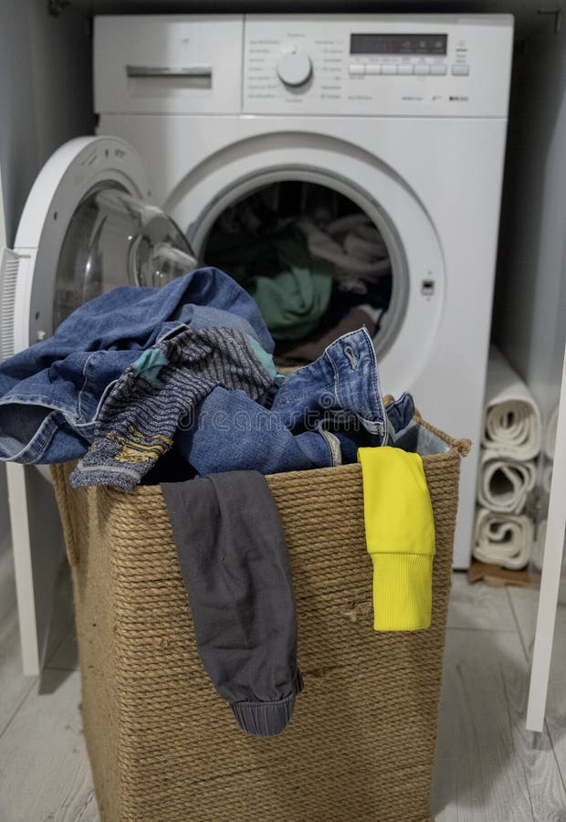 A Basket of Dirty Laundry in Front of an Open Washing Machine Stock ...