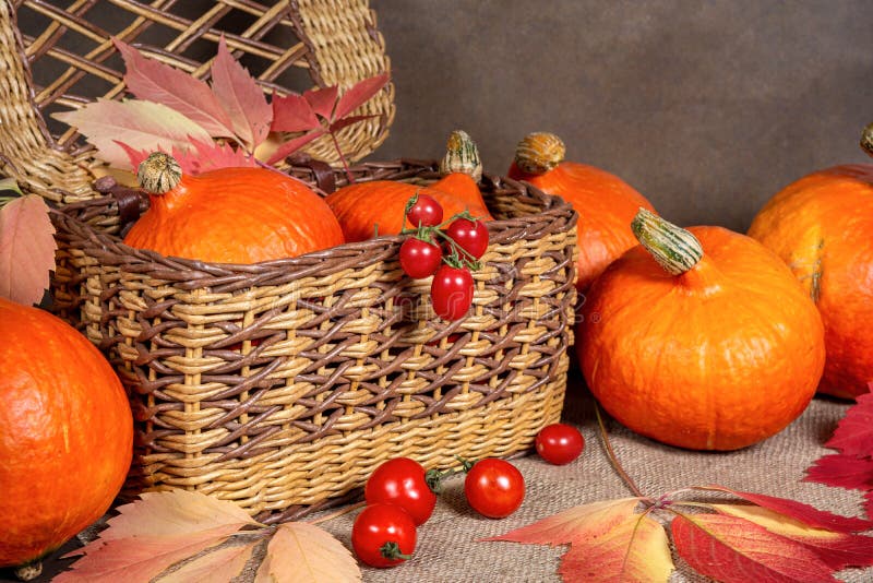 Basket on the Table with Pumpkins, Tomatoes and Autumn Leaves Stock ...