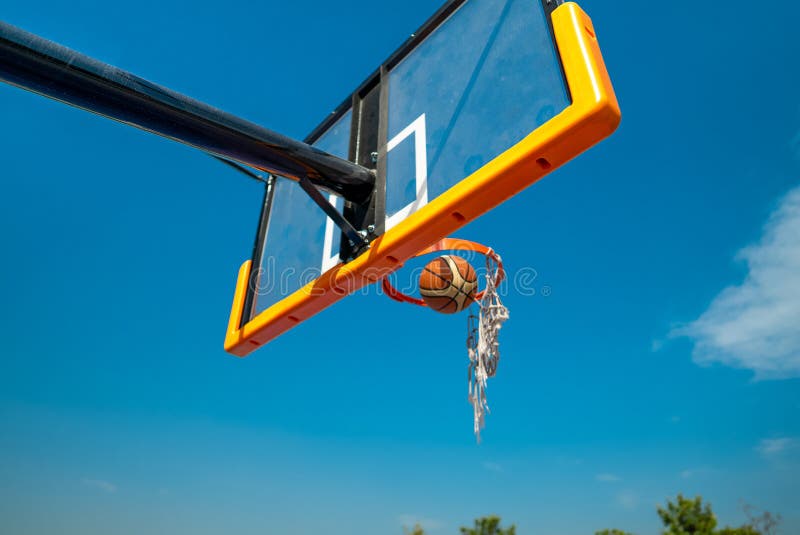 Basketball Ball Falling through Old Net. Blue Sky on Background Stock ...