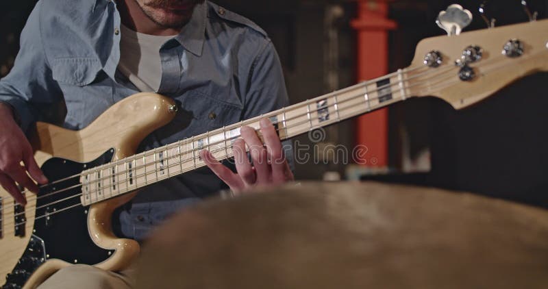 Bass Guitarist Practicing in Studio: Close-Up of Hands Playing a Four ...