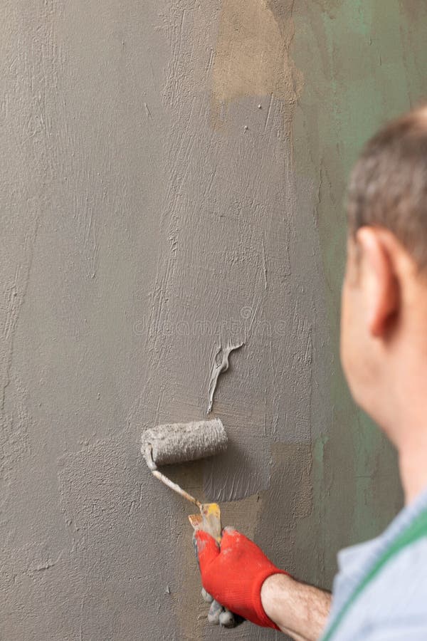 In the Bathroom, a General Construction Worker Applies Moisture ...