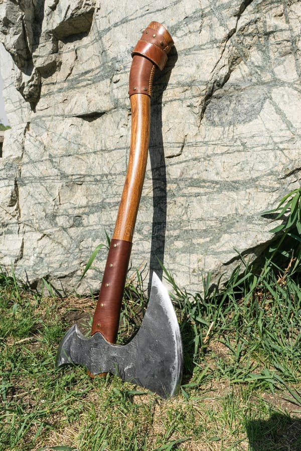 The Battle Ax is on the Ground Next To a Large Stone Stock Image ...