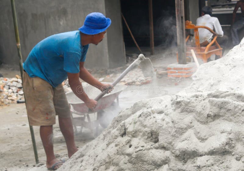 A Construction Worker Transports Sand with a Shovel. Editorial ...