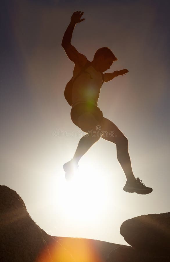Be Bold and Take Risks. a Silhouette of a Man Jumping Over Rocks. Stock ...