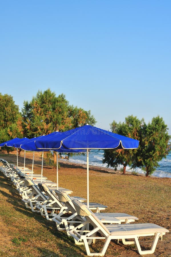 Beach with blue parasols stock photo. Image of sandy - 15617882