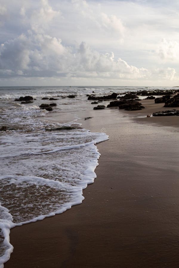 White Foam of Waves on the Beach Sand on a Cloudy Day Stock Image ...
