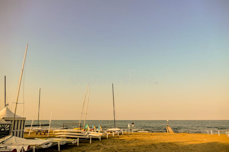 A Beach with a Few Boats and a Person Standing on the Sand Stock Photo ...