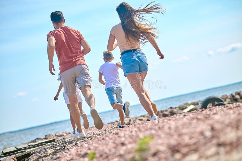 A Happy Family Feeling Excited and Running on a Beach Stock Photo ...