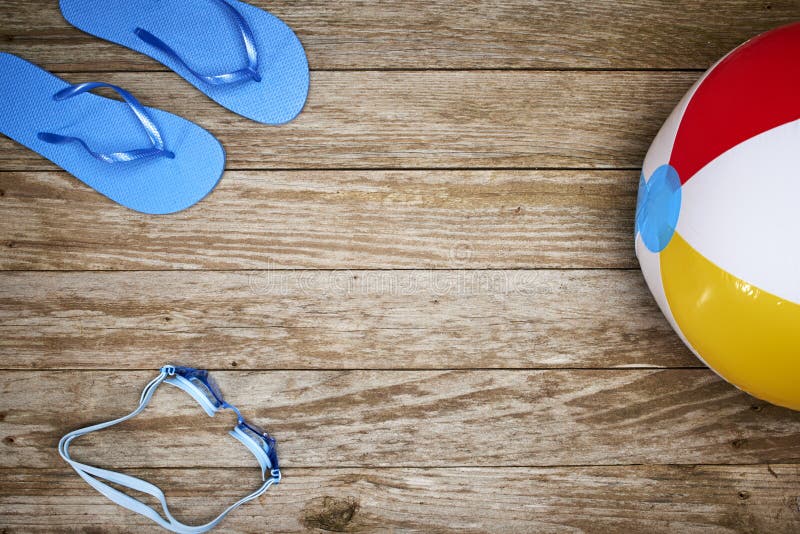 At the beach, Beach items including a beach ball, flip flops, and