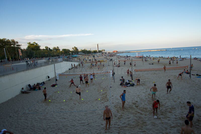 A Beach with a Large Crowd of People Playing Volleyball Editorial ...