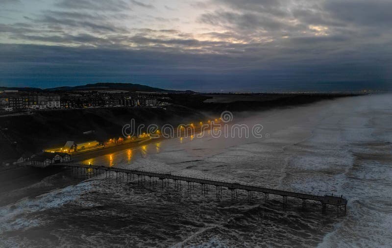 The Evening View of an Ocean Beach with Lights on it Stock Photo ...