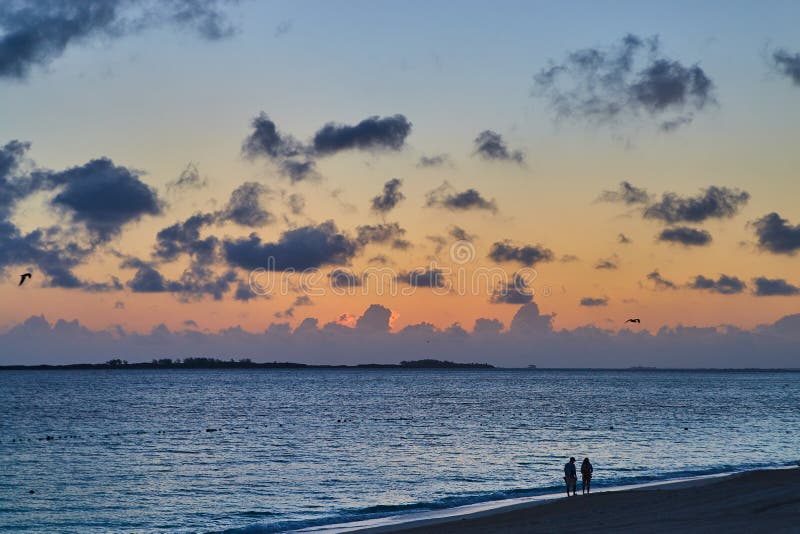 Beach and Ocean with Two Figures during Sunset with Soft Muted Sky ...