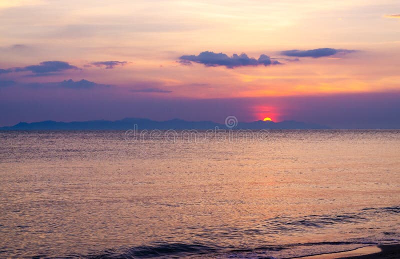 The Beach Overlooking the Sunset Behind the Mountain Stock Photo ...