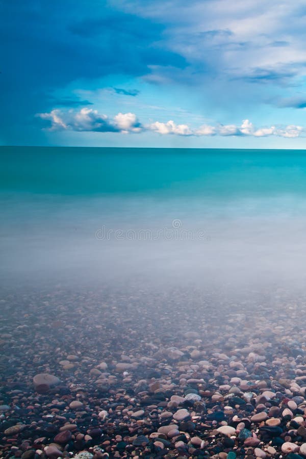 Beach Pebbles Smooth Blue Sea Under Blue Sky Stock Image - Image of ...