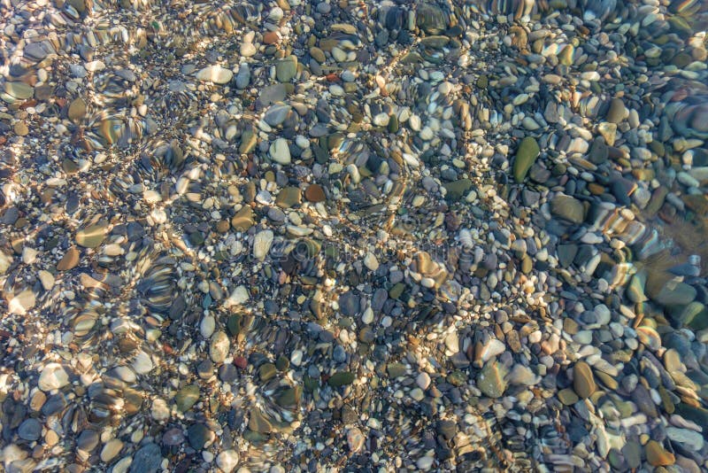 Beach Pebbles Under Clear Water with the Solar Pattern of Ripples Stock ...