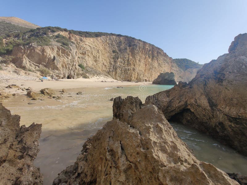 Beach with Rock Cliffs and People on the Shore. Stock Photo - Image of ...