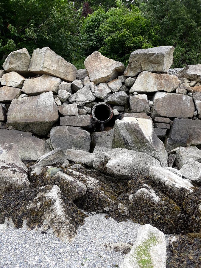 Beach rocks drain pipe stock image. Image of sculpture - 192488833