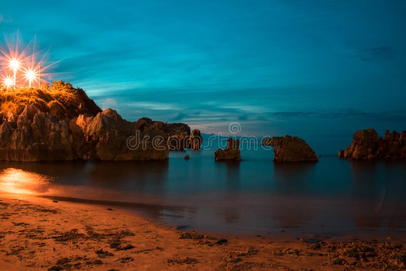 Beach with Rocks and Night Lights. the Idyllic Concept Stock Photo ...