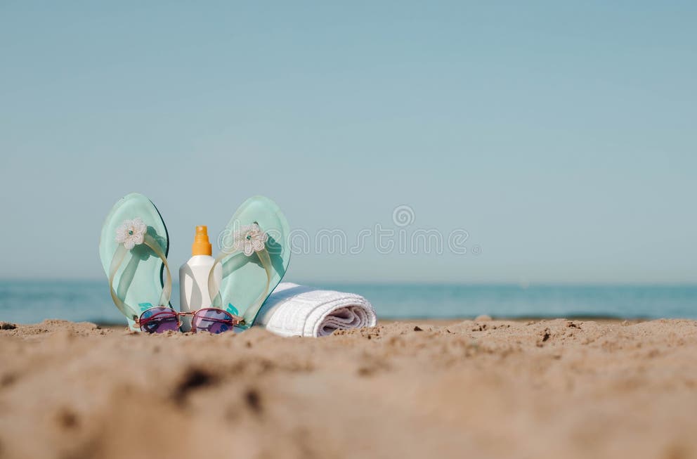 Beach Sandals and Sunscreen on Sandy Shore by the Ocean Stock Image ...