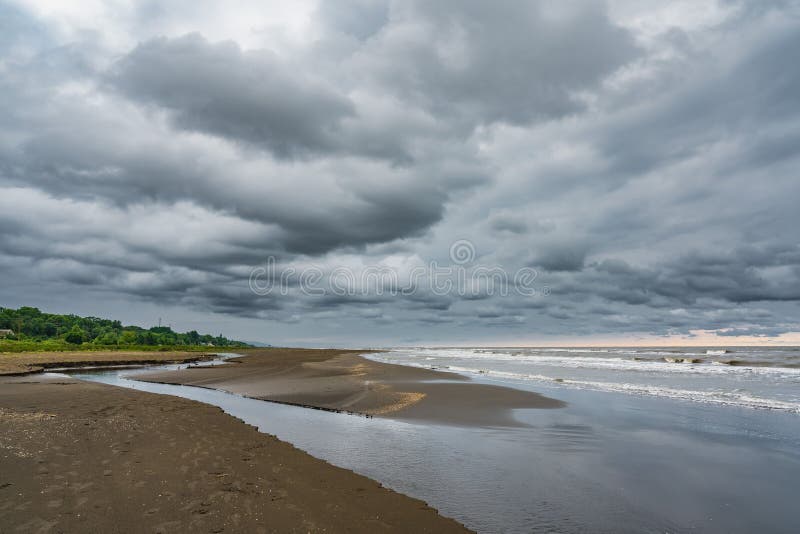 Beach Scene Featuring a Large Puddle of Water Near the Edge of the ...