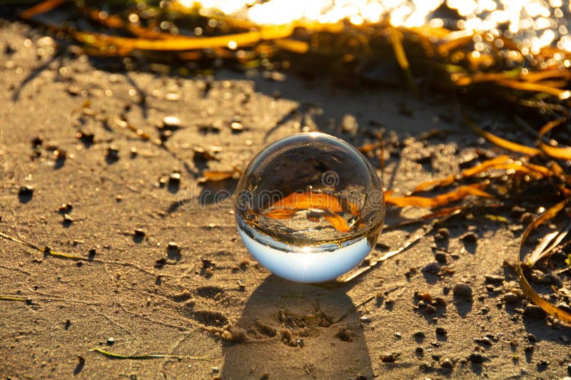 The Beach and the Sea are Reflected in a Sphere Lying in the Sand Stock ...