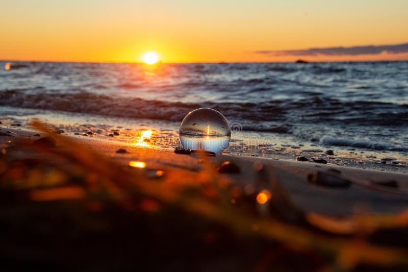 The Beach and the Sea are Reflected in a Sphere Lying in the Sand Stock ...