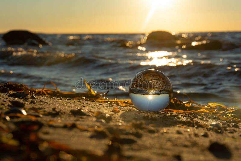 The Beach and the Sea are Reflected in a Sphere Lying in the Sand Stock ...