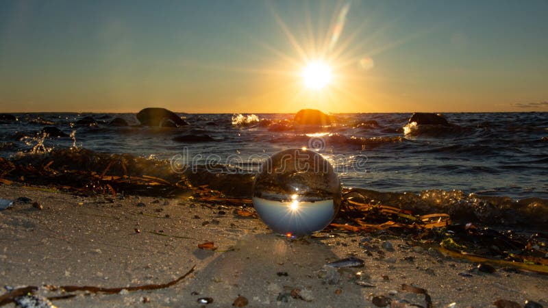 The Beach and the Sea are Reflected in a Sphere Lying in the Sand Stock ...