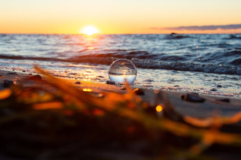 The Beach and the Sea are Reflected in a Sphere Lying in the Sand Stock ...