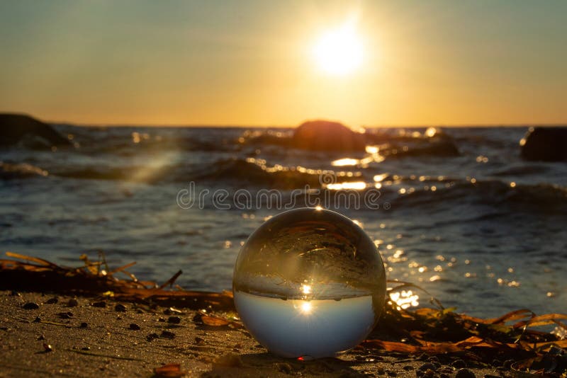 Beach and Sea Reflected in a Sphere Lying in the Sand in the Waves ...