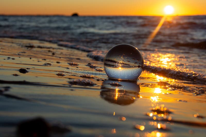 Beach and Sea Reflected in a Sphere Lying in the Sand in the Waves ...