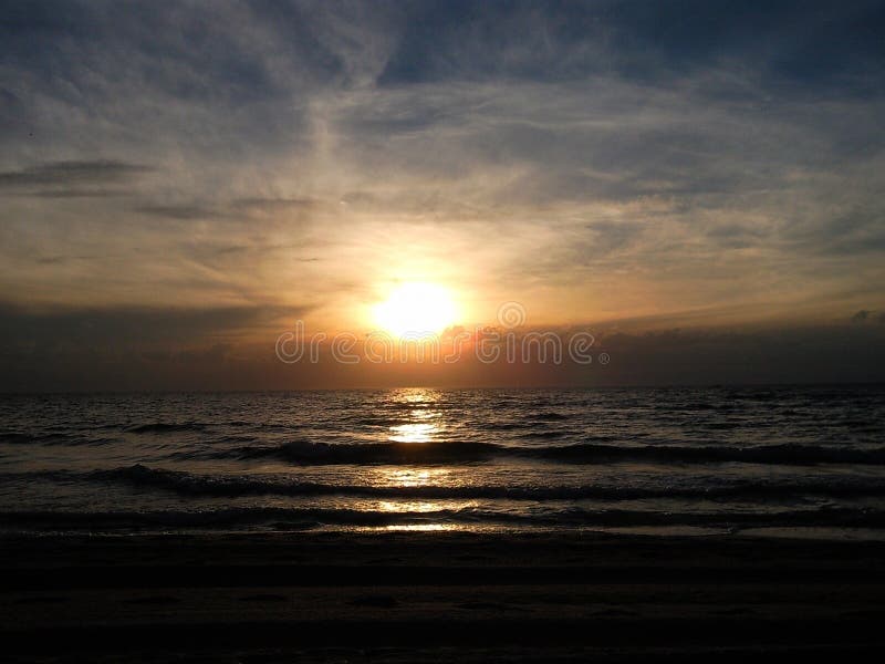 Beach Sunset with Light Reflecting Across the Waves Stock Image - Image ...