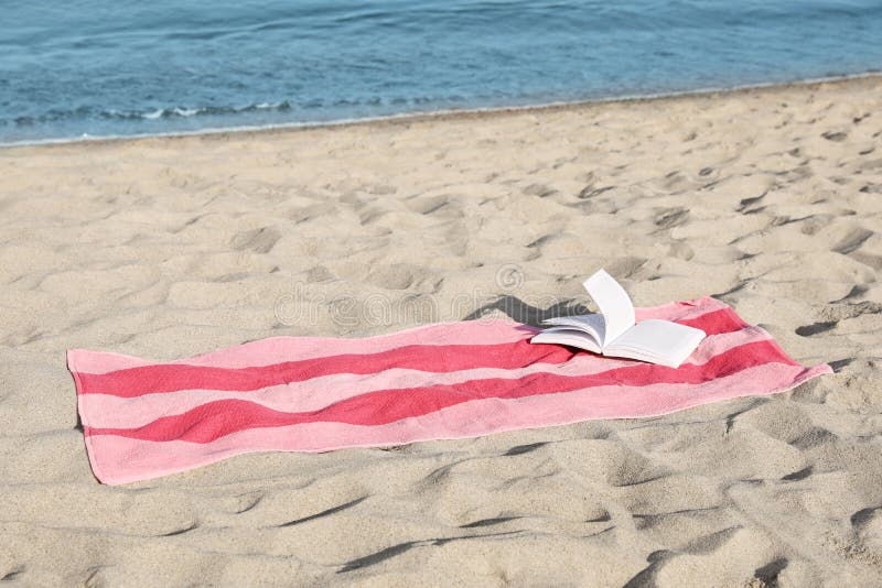 Beach Towel and Open Book on Sand Near Sea Stock Photo - Image of ocean ...