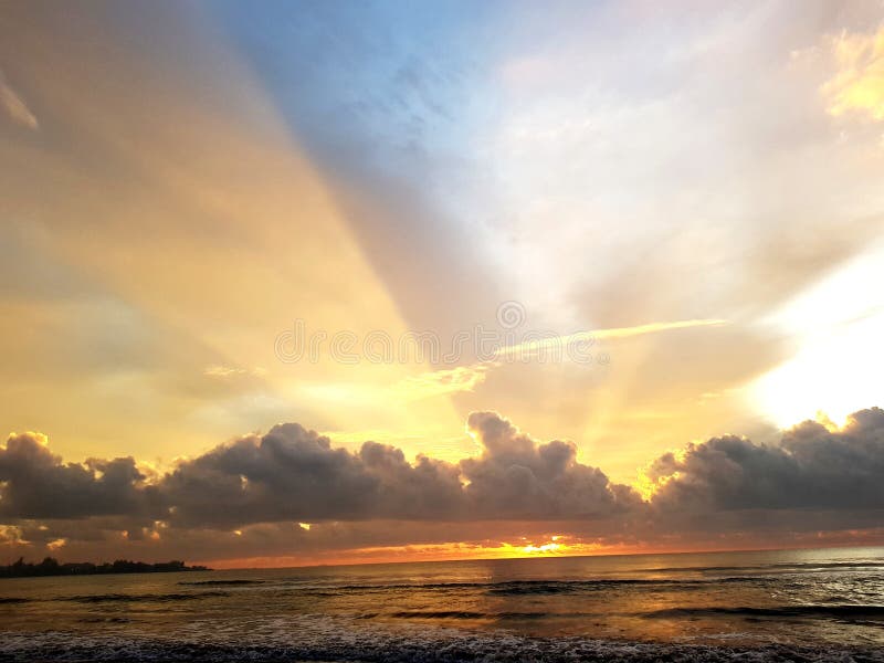 Beachside Sunset View with Rays of Light in the Clouds, with Waves ...