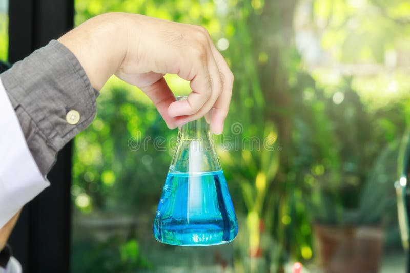 Beaker with Blue Experiment Liquid in Scientist Hand on Laboratory ...