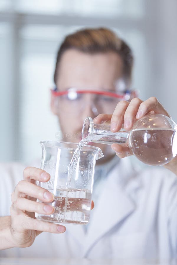 Beaker and Flask with Liquids in the Hands of the Scientist Stock Photo ...
