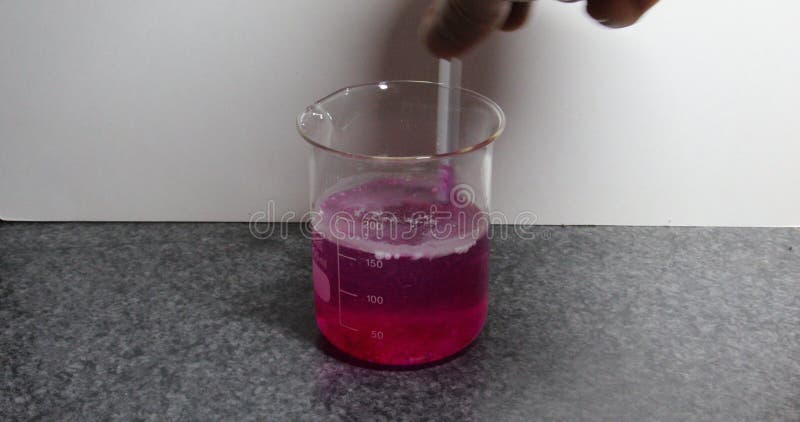 Beaker with Liquid is Coloured Dark Purple by Adding a Powder Stock ...