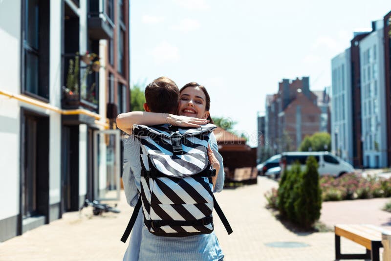Beaming Wife Hugging Her Man Wearing Backpack Stock Photo - Image of ...