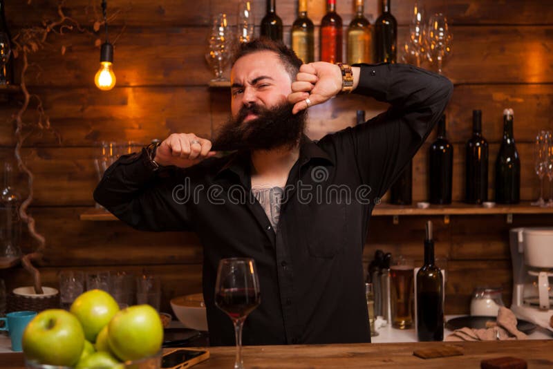 Bearded Barman Being Funny with His Beard Behind the Counter. Stock ...
