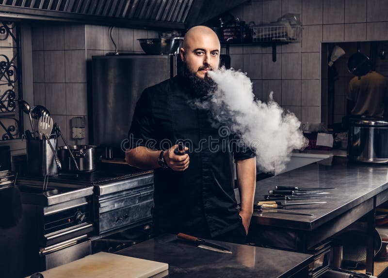 Bearded Chef in Black Uniform Smoking E-cigarette while Standing in the ...