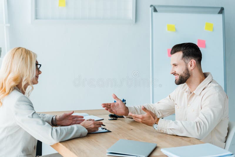 Bearded Employee Gesturing Near Attractive Recruiter Stock Photo ...