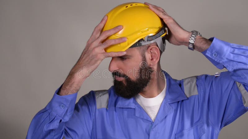 Bearded Engineer Touch Safety Helmet with Hands on Grey Background ...
