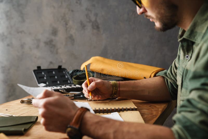 Bearded Focused Craftsman Writing Down Notes while Sitting at Table ...