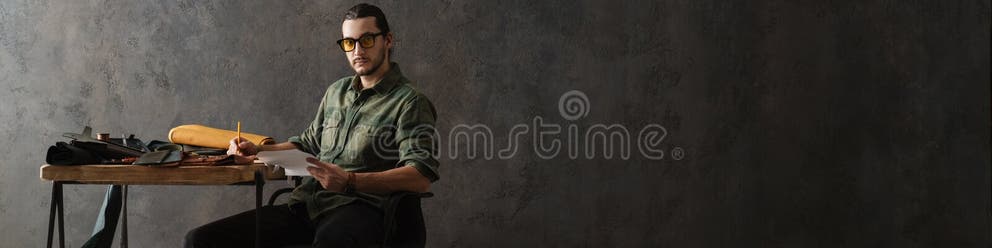 Bearded Focused Craftsman Writing Down Notes while Working with Leather ...