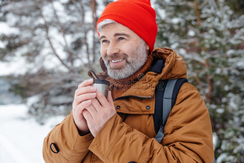 Bearded Gray-haired Man in Red Hat with Thermos in Hands in a Winter ...