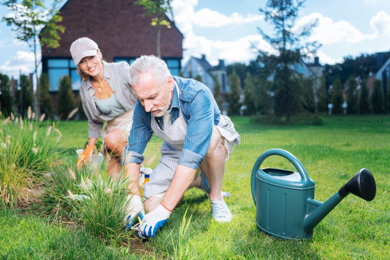 Bearded Grey-haired Husband Supporting and Helping His Wife in Garden ...