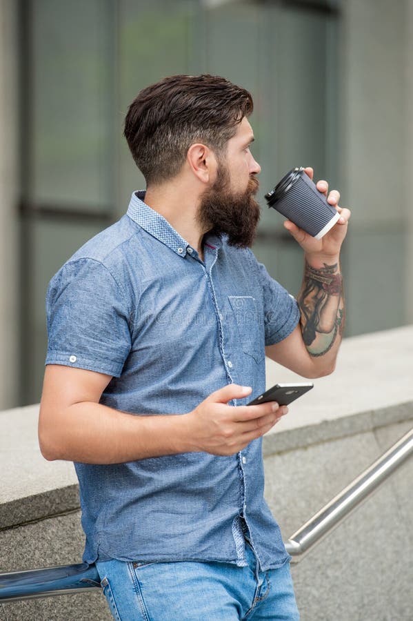 Bearded Guy Texting Via Mobile Phone while Drinking Coffee Outdoors ...