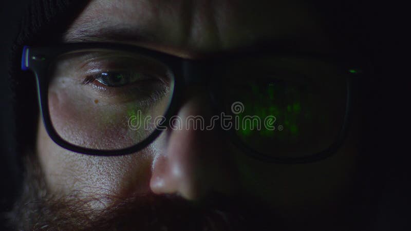 Bearded Hacker in Eyeglasses Working on Computer in the Night Green ...