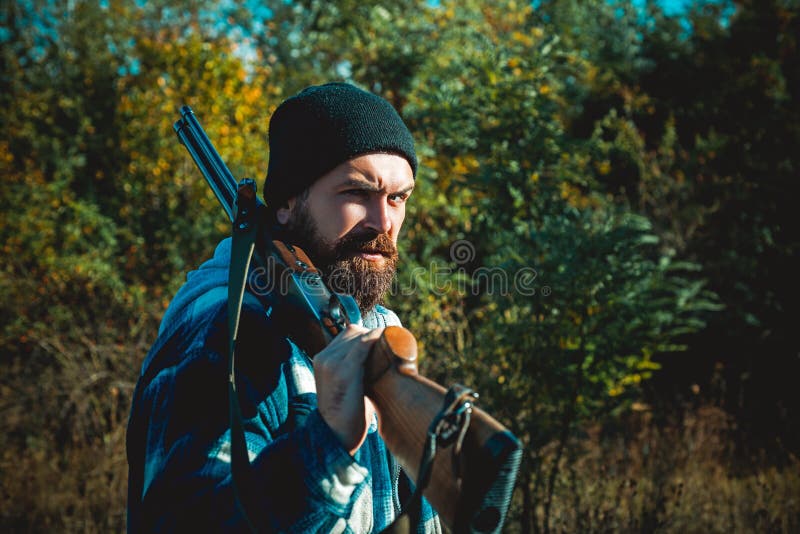 Bearded Hunter Man Holding Gun and Walking in Forest. Hunter with ...